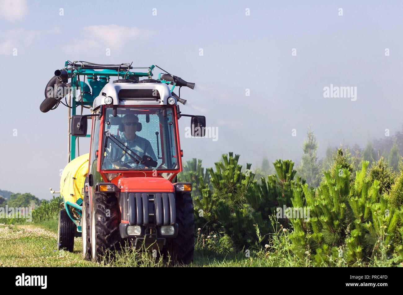 2008 - Farmer driving a small tractor and pulling a small pesticide ...
