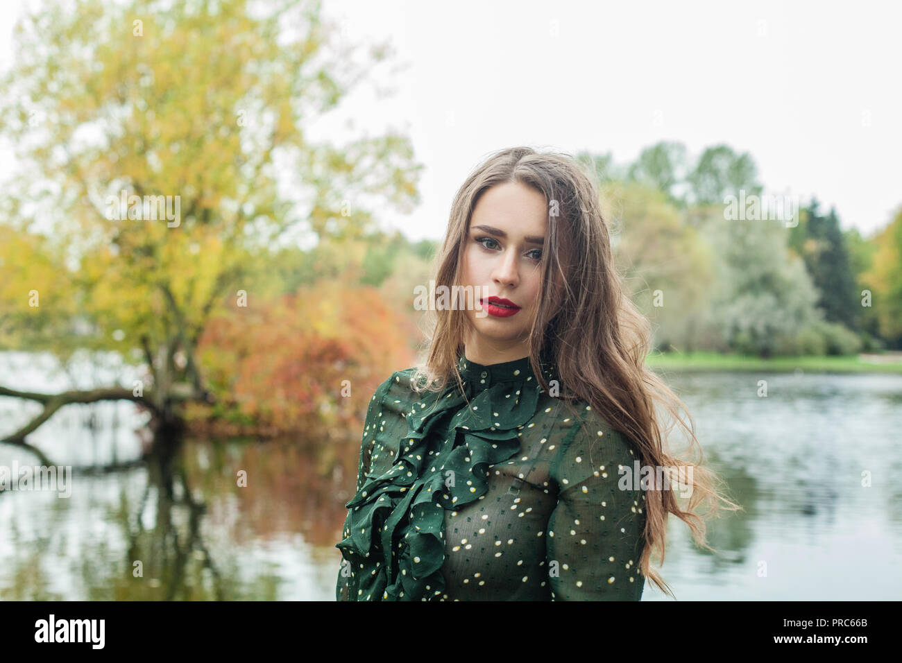 Beautiful woman outdoor autumn portrait. Perfect female model in green ...