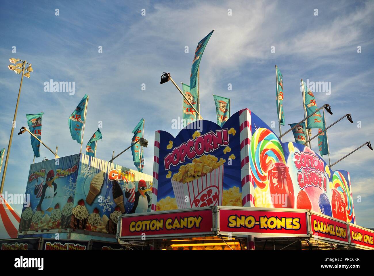 A close-up of a carnival stand with a popcorn & cotton candy sign at ...