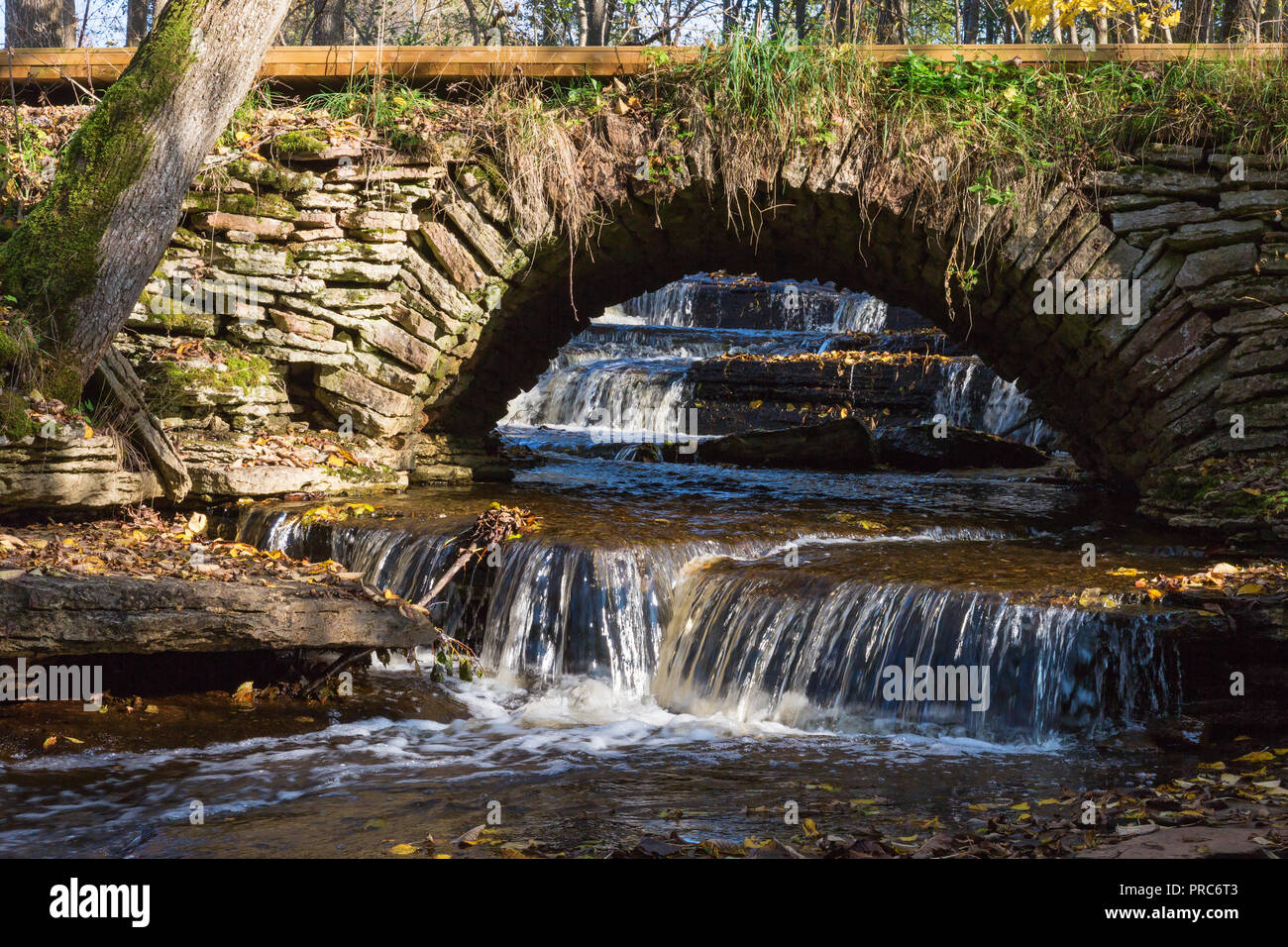 Old arch bridge with waterfall Stock Photo - Alamy