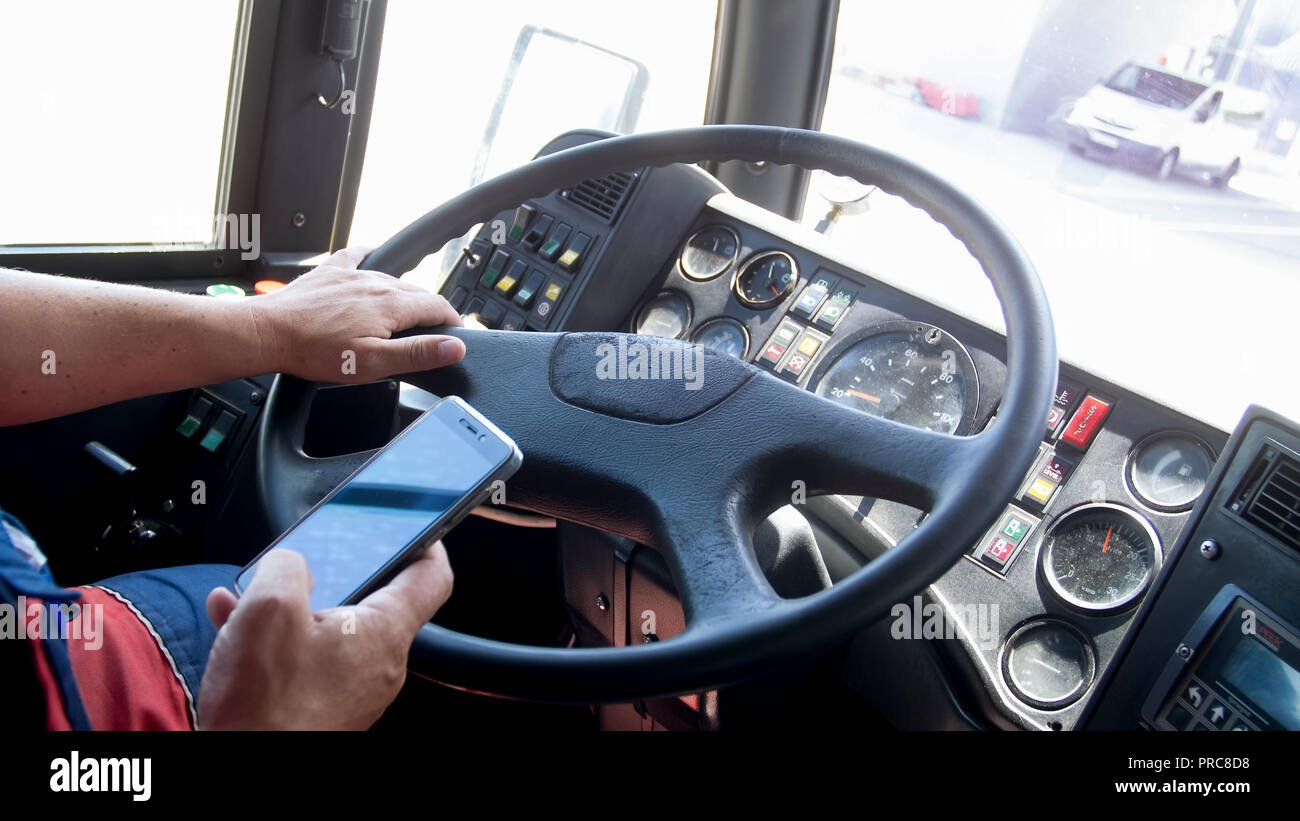 Closeup photo of driver holding smartphone while driving bus Stock ...