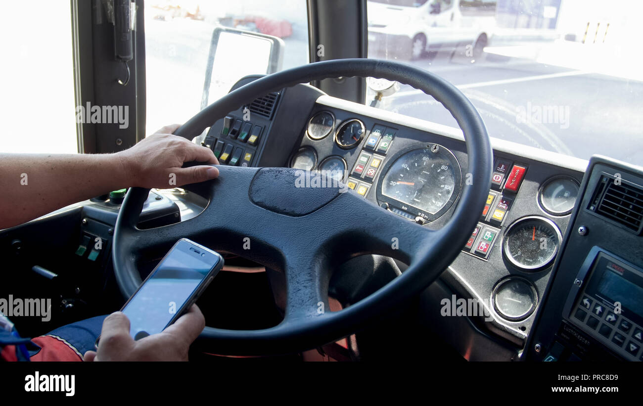 Closeup image of truck driver typing on smartphone while driving ...