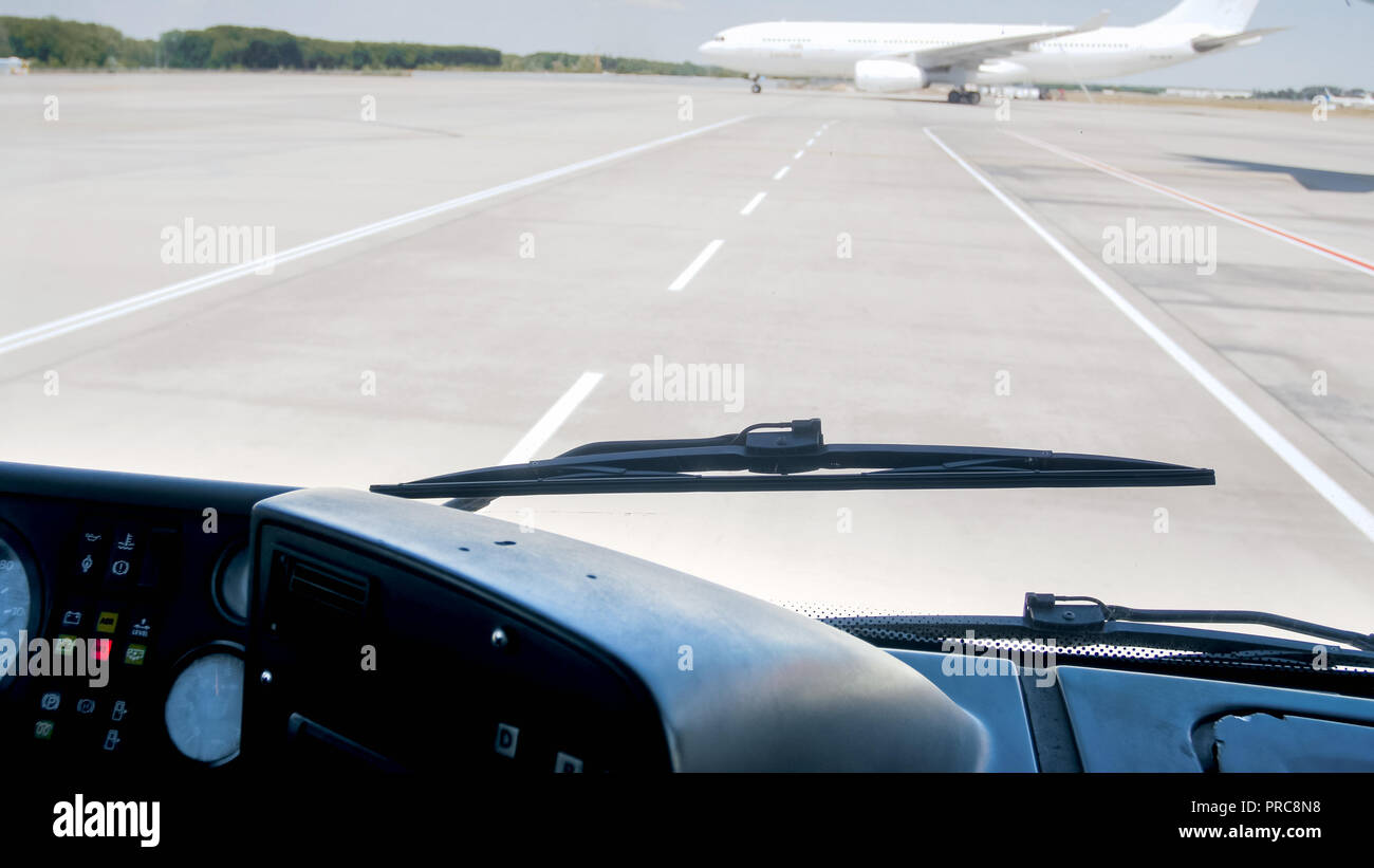 Photo of bus with passengers riding towards jet airplane on airport ...