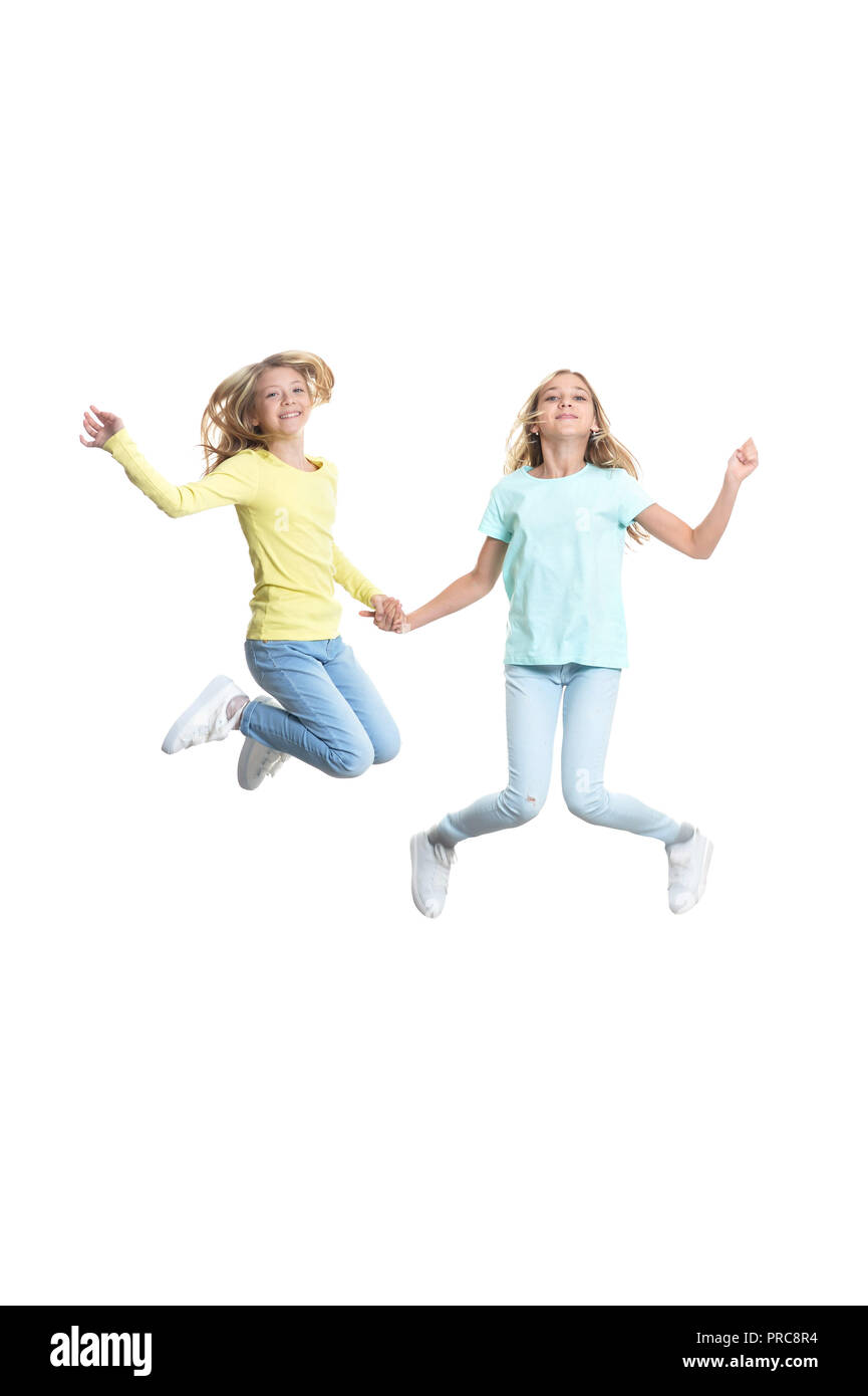 Cute girls in casual clothing jumping on white background Stock Photo ...