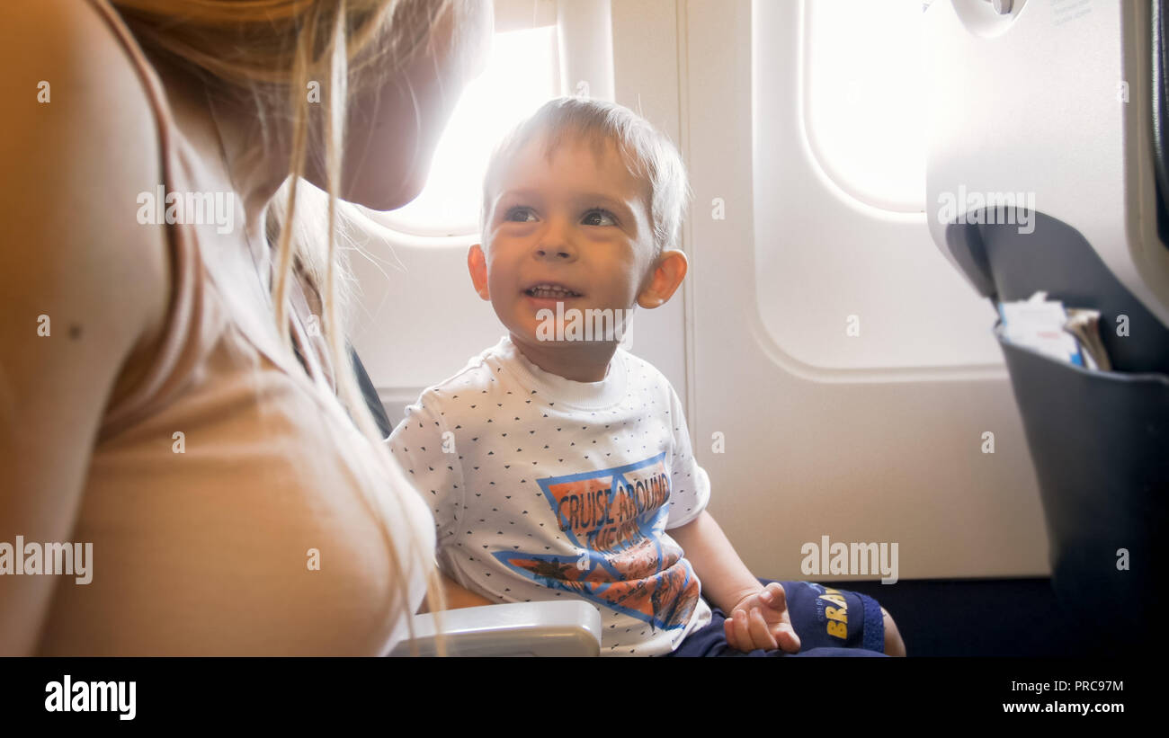 Portrait of adorable smiling toddler boy looking at mother during first ...