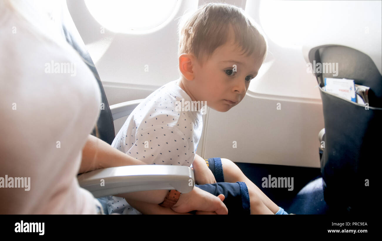 Little toddler boy feeling nervous before first flight in airplane ...