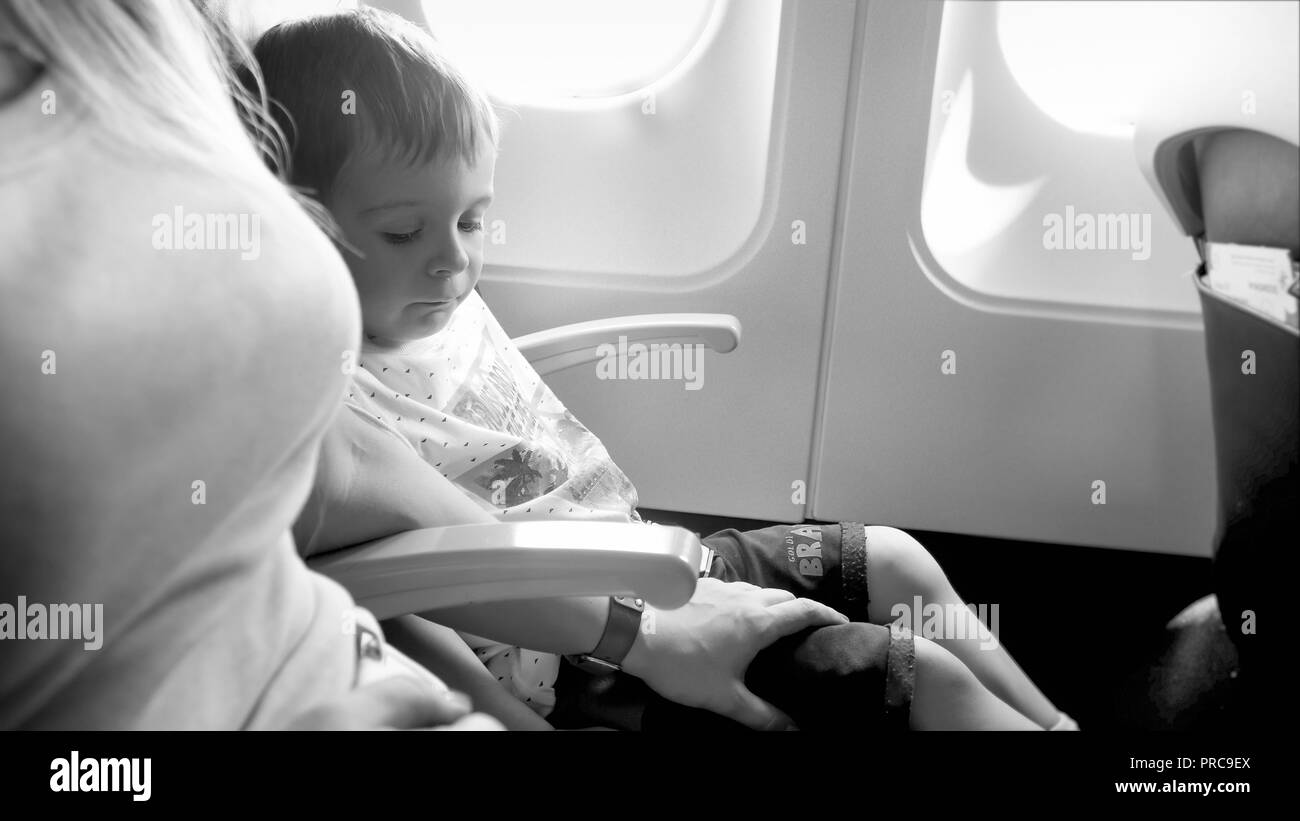 Black and white photo of young mother calming her toddler son scared of ...