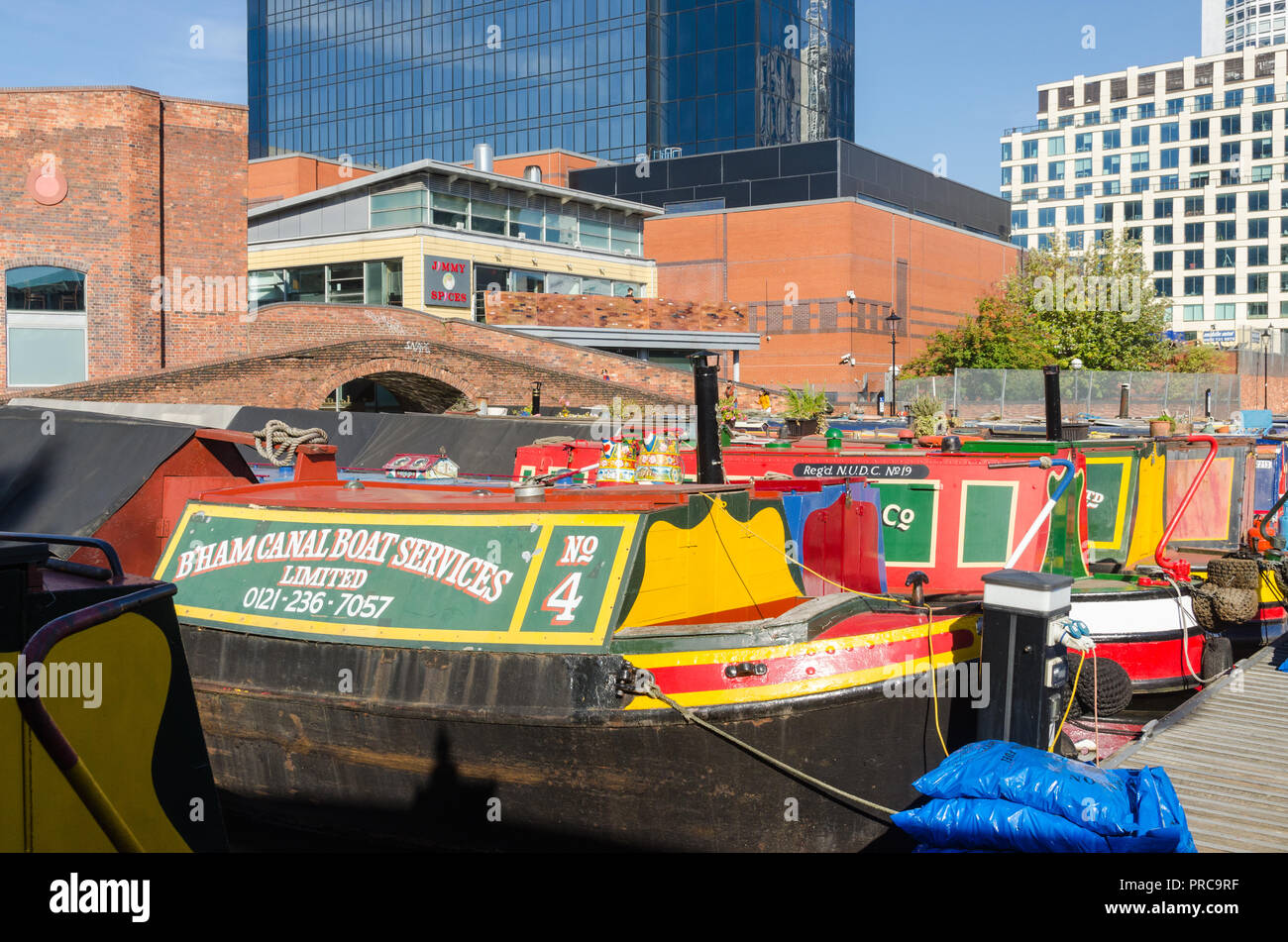 Colourful narrow boats moored in gas street basin at the heart of ...