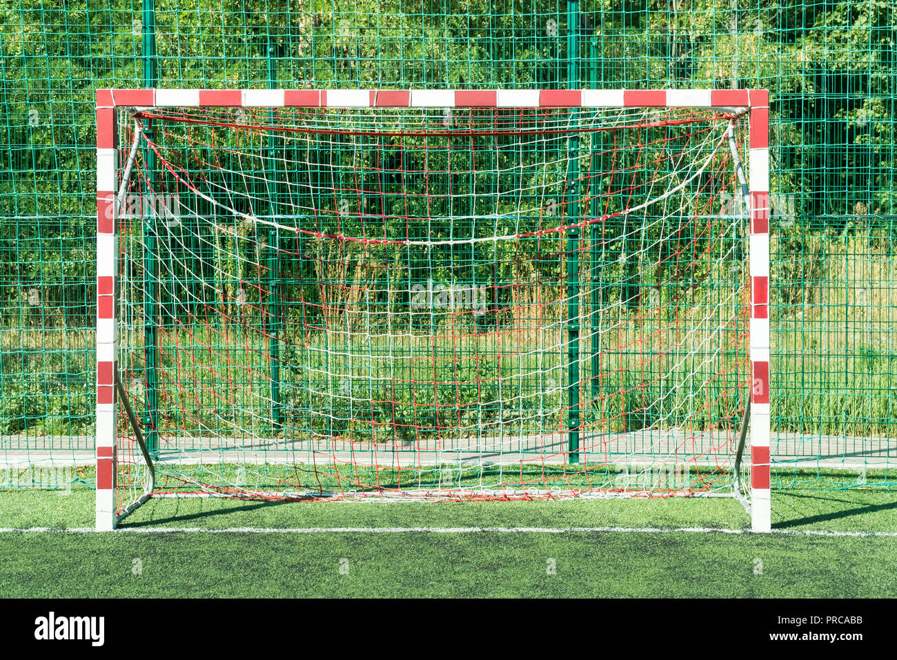 Goal in white and red stripes for mini football on an artificial grass ...