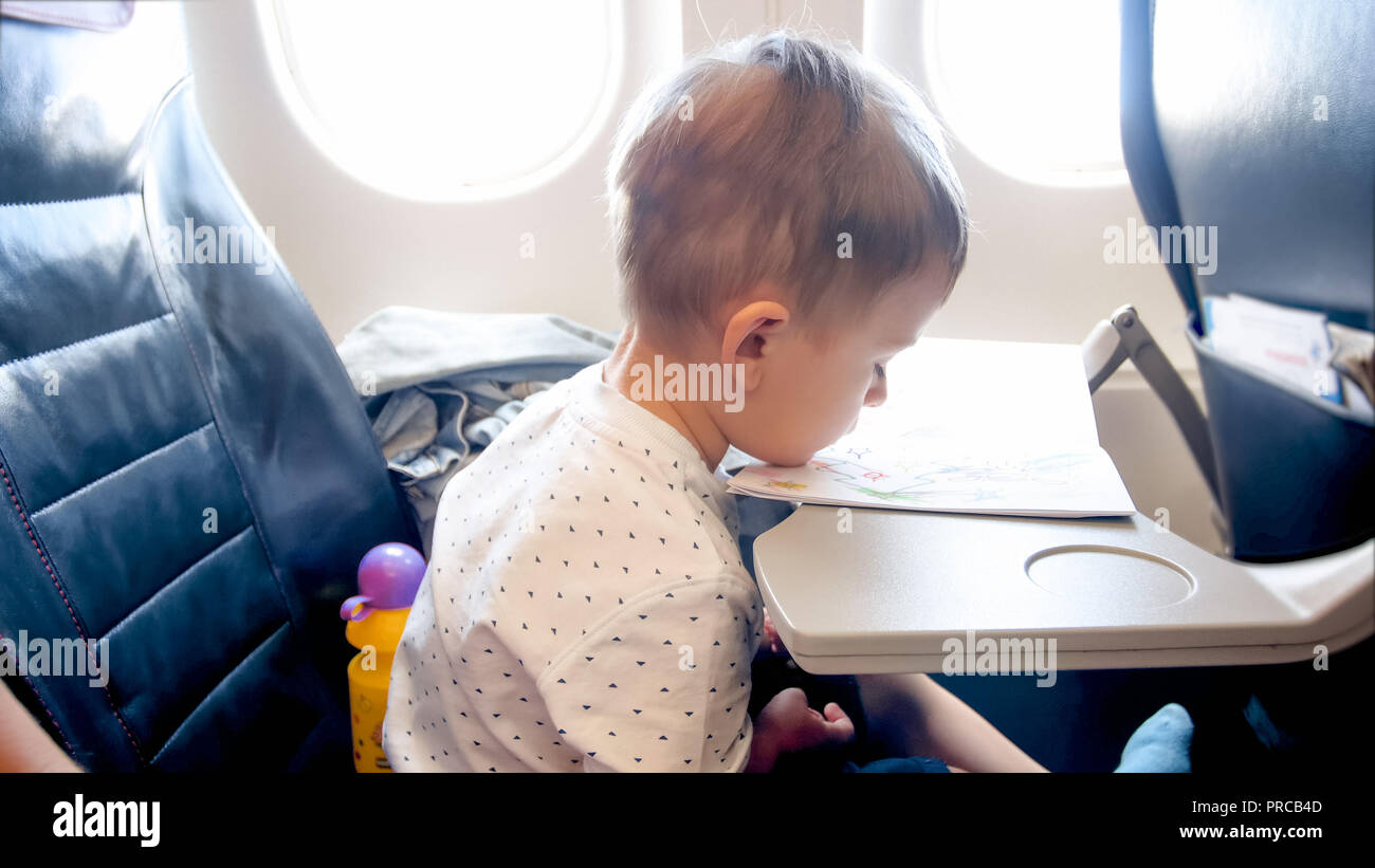 Portrait of tired of flight little boy flying in airplane Stock Photo ...