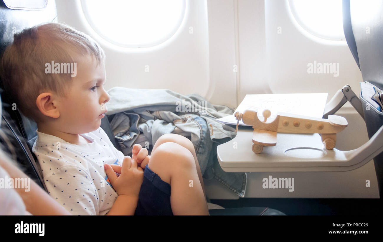 Little toddler boy sitting in passenger seat with wooden toy airplane ...