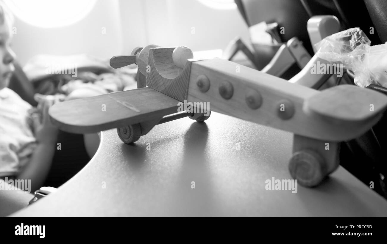 Closeup black and white photo of wooden miniature airplane against ...
