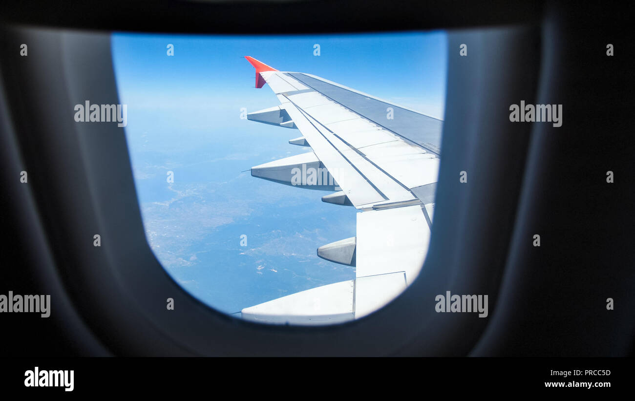 View from the passenger seat on airplane wing above clouds Stock Photo ...