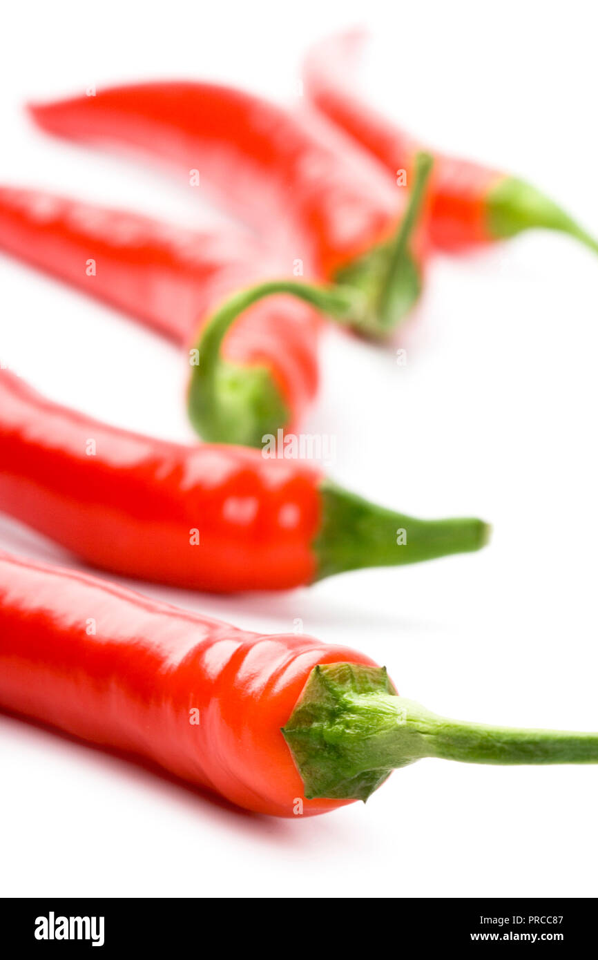 five red chili peppers closeup on white background Stock Photo - Alamy