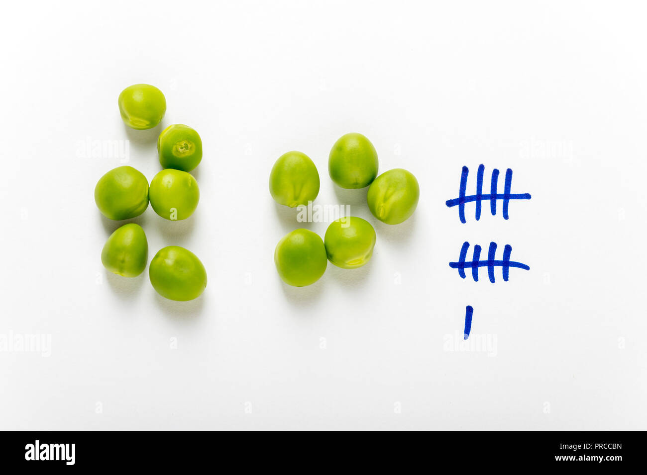 counting peas on white background Stock Photo - Alamy