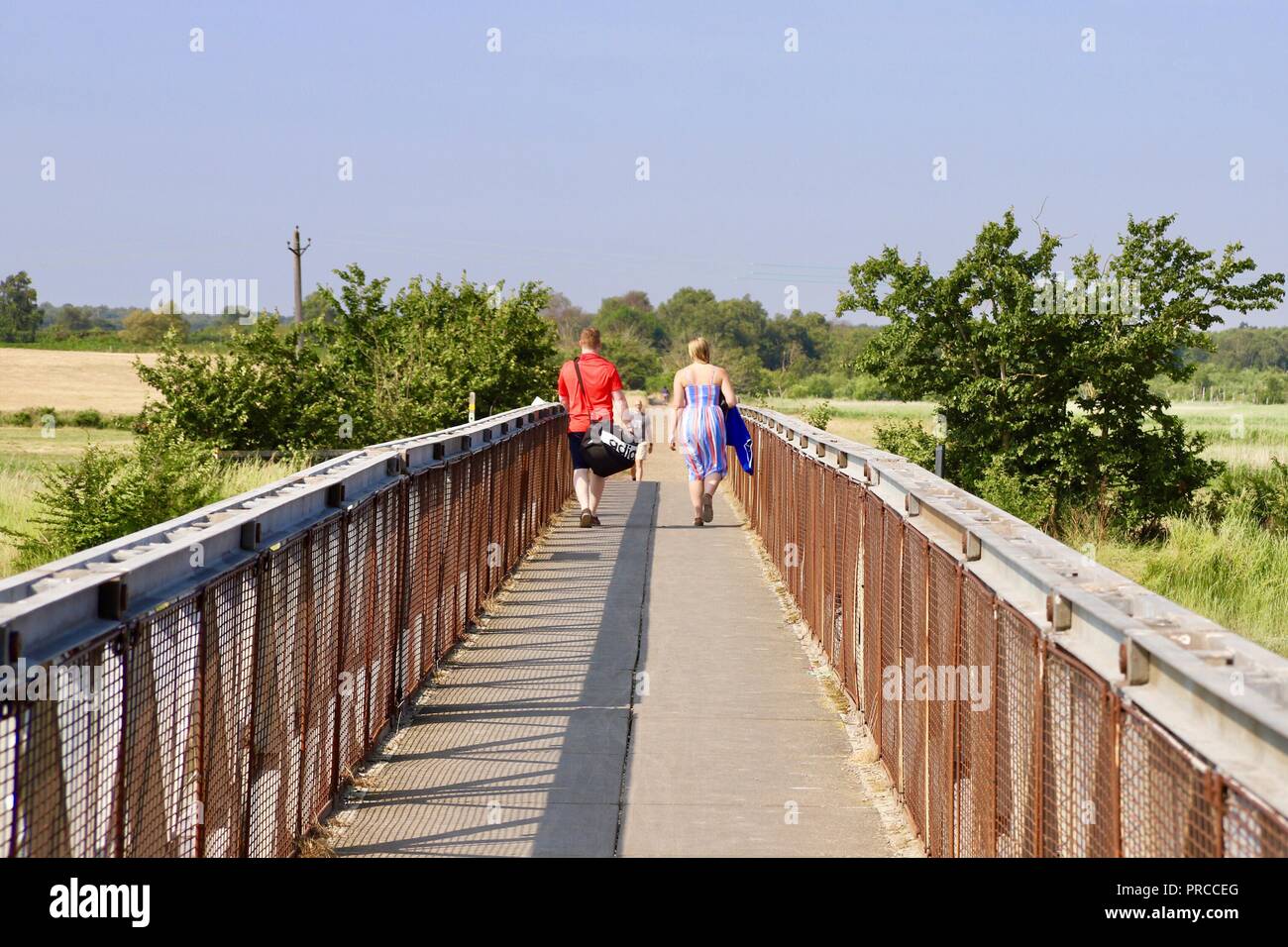 A couple walk across the bailey bridge over the River Blyth from ...