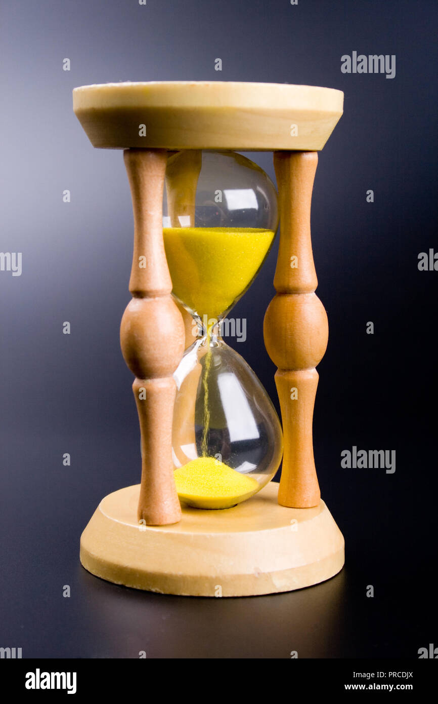 sand clock showing how is time passing on black background Stock Photo ...
