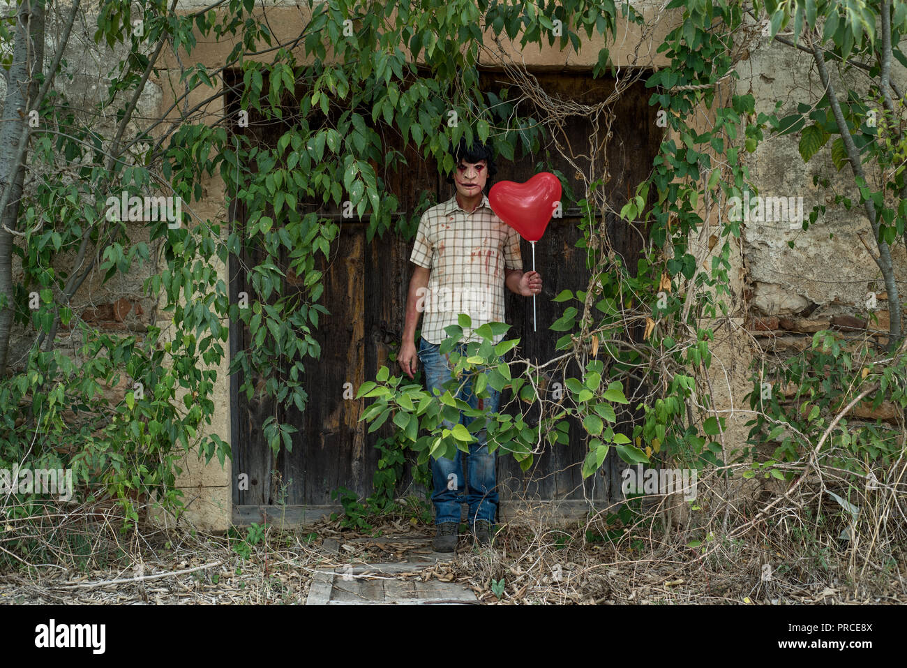 a scary disfigured man, wearing dirty and ragged clothes, with a red ...