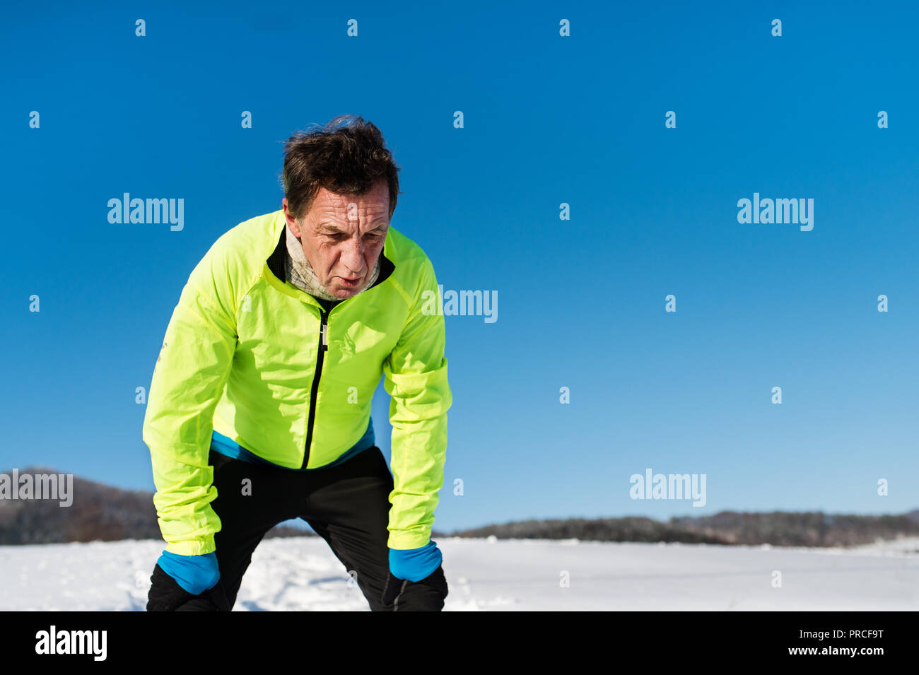 A portrait of senior man standing after the run in winter nature Stock ...