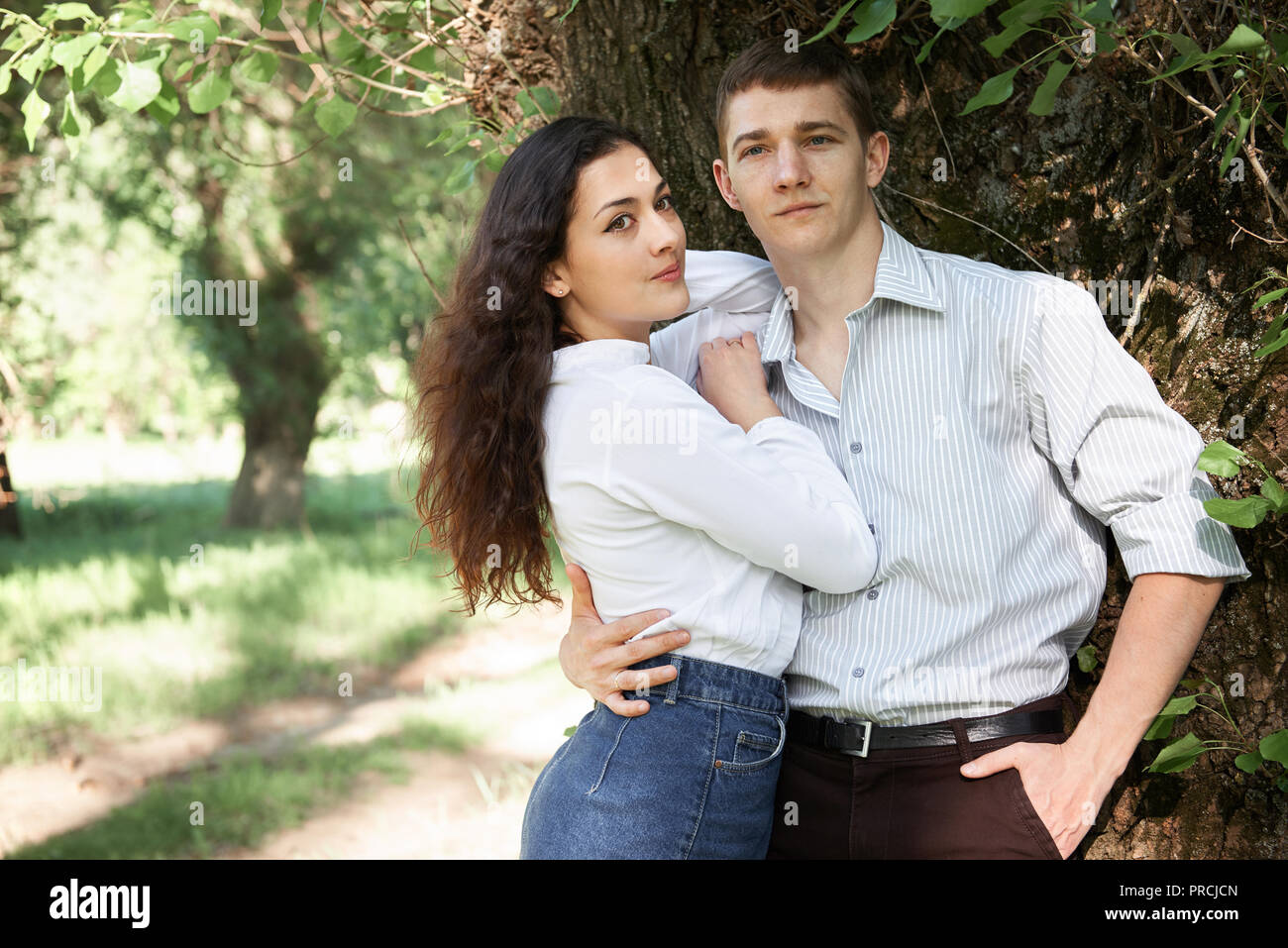 young couple walking in the forest, posing near tree, summer nature ...