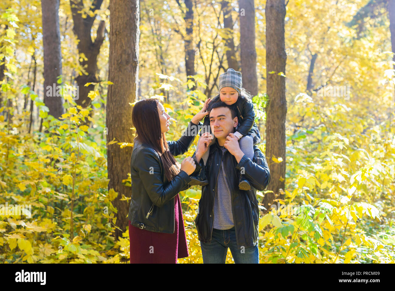 Family, autumn, people concept - young family walking in autumn park ...