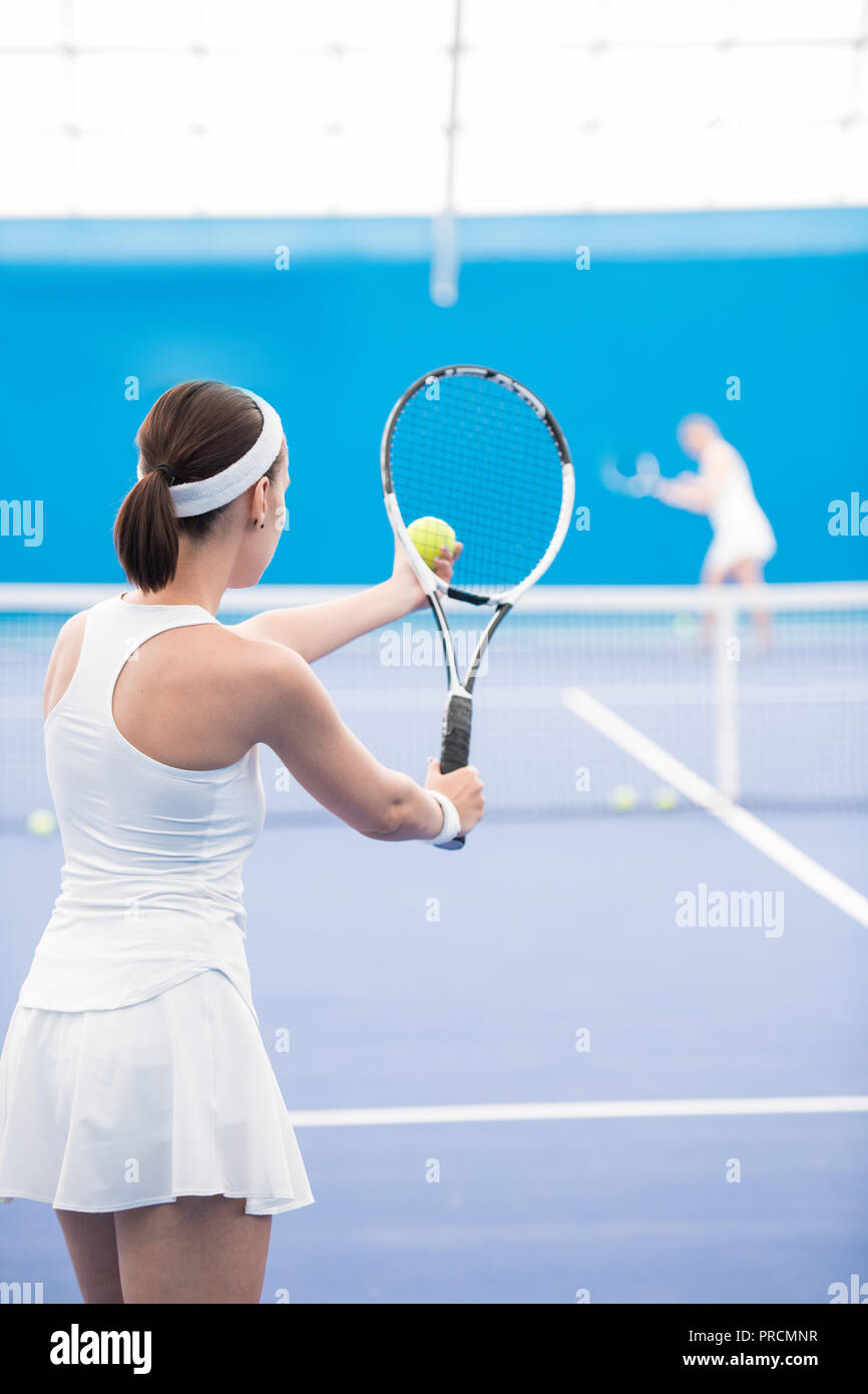 Female Tennis Player Serving Ball in Match Stock Photo - Alamy