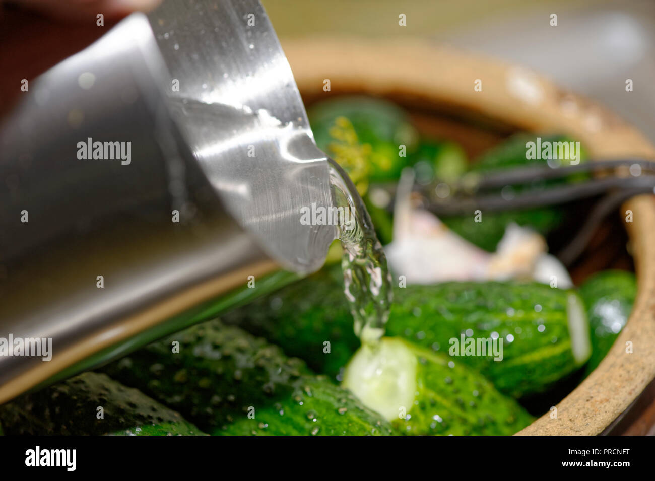 Pickled green cucumbers in glass jars on kitchen countertop Stock Photo ...