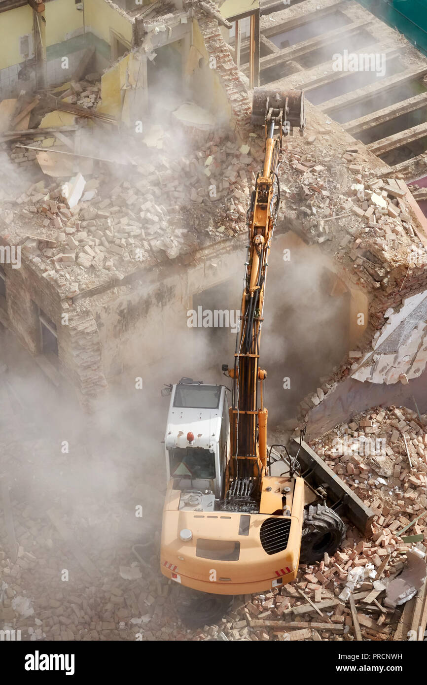 Building demolition with an excavator in dust cloud, view from above Stock Photo - Alamy