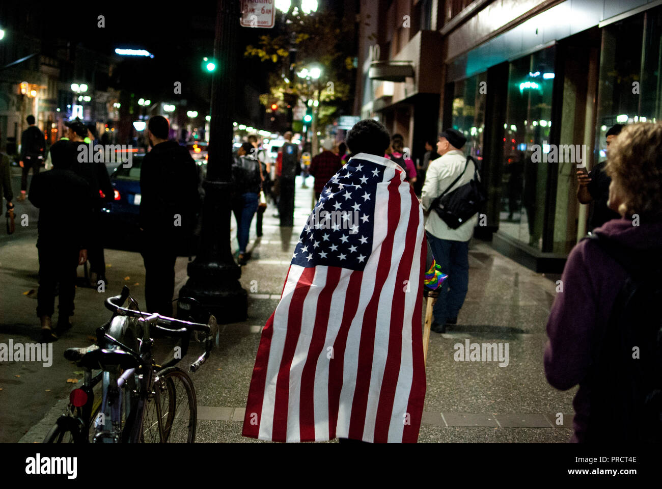 A protester wrapped in an American flag walks on Broadway in downtown ...
