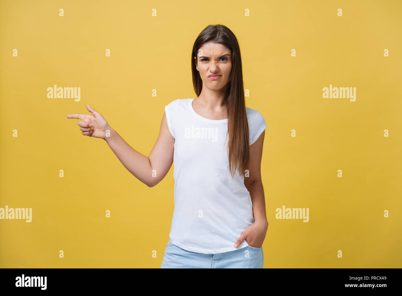 Closeup portrait of young pretty unhappy, serious woman pointing at ...