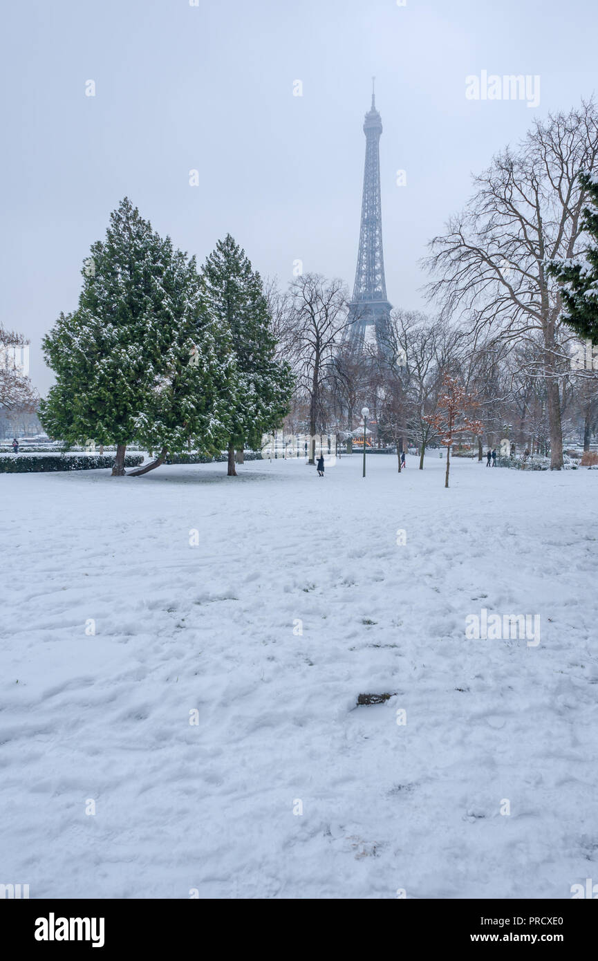 Eiffel tower under the snow behind trees from the Trocadero gardens in ...