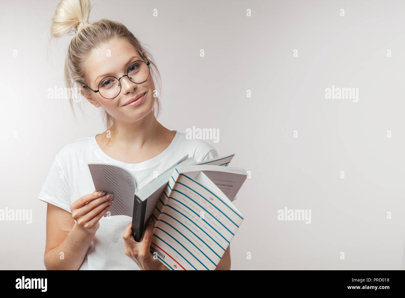 Portrait of young student girl with books isolated over grey wall ...