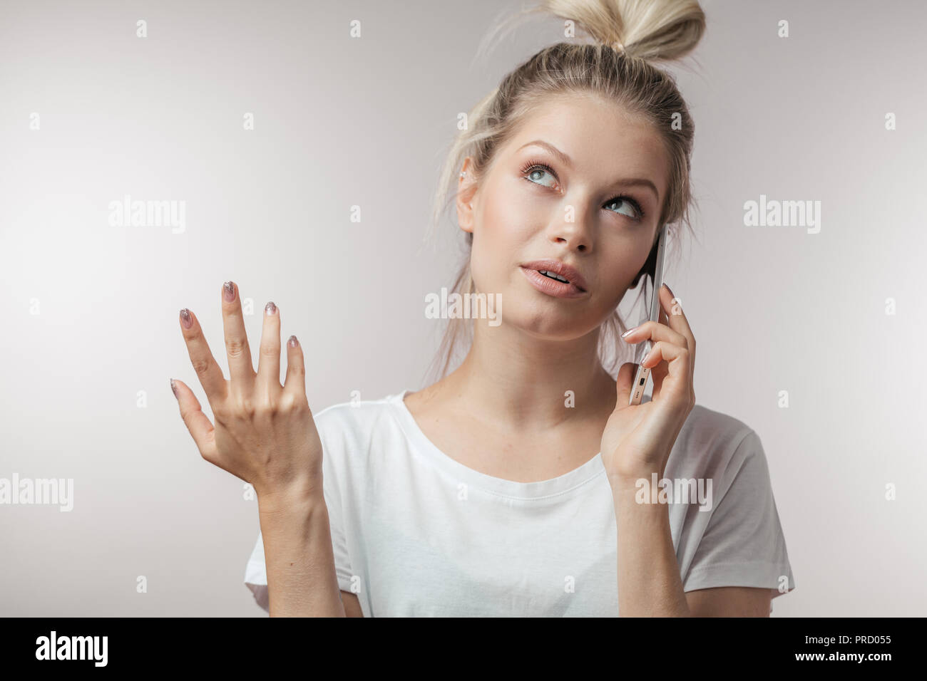 Confused puzzled woman holding her smart phone. Human emotions, body ...