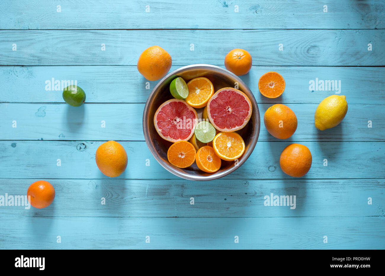 Mix of fresh ripe citrus fruits in a bowl on a blue background Stock ...