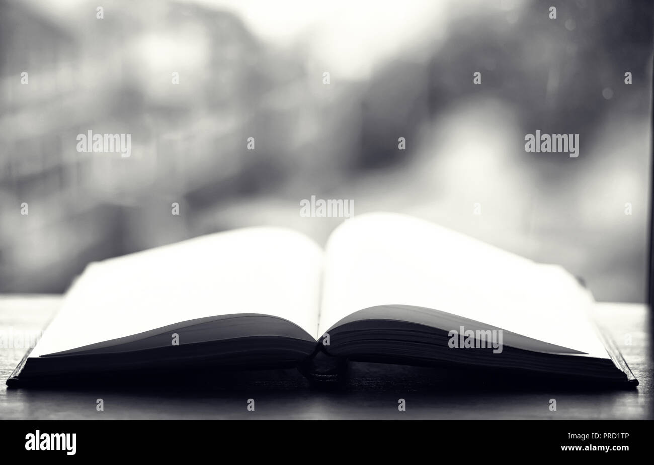 open book and a table in front of the window Stock Photo - Alamy