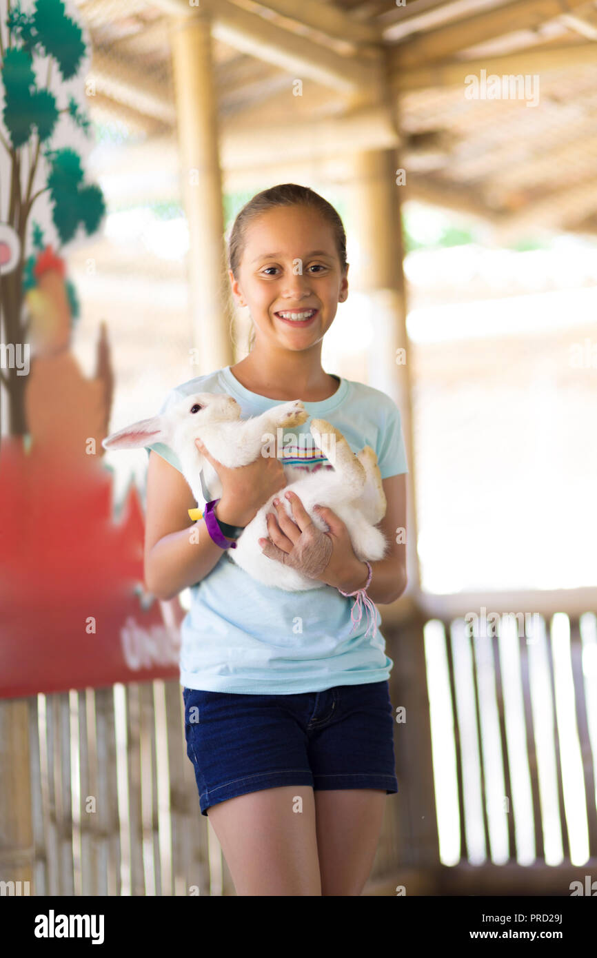 Happy Girl Playing with Rabbit in the Farm Stock Photo - Alamy