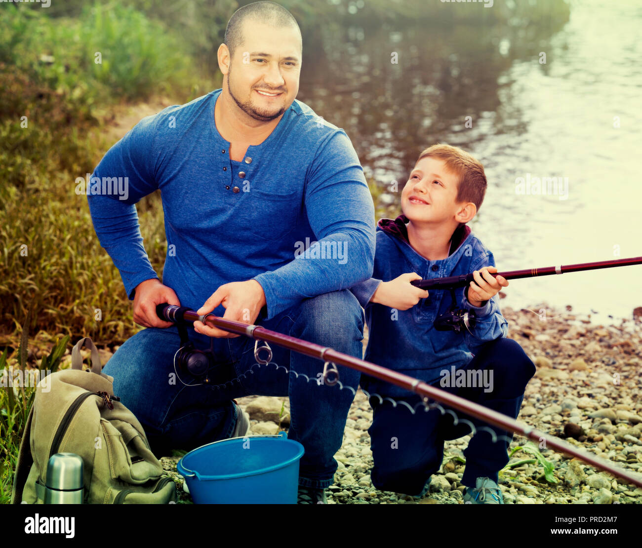 Portrait of father and cute son fishing with rods in summer day Stock ...