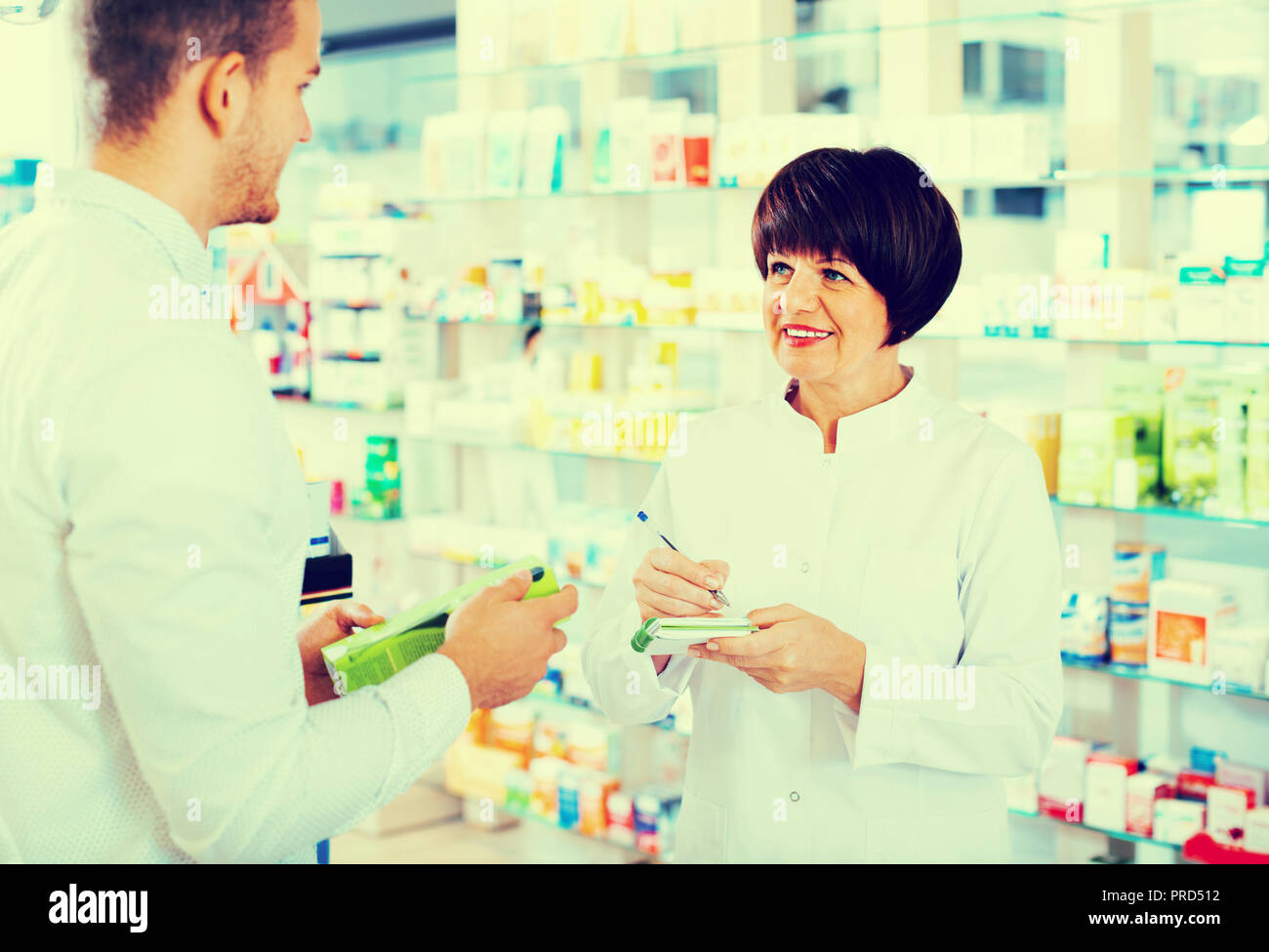 Smiling glad cheerful female pharmacist wearing uniform working in ...