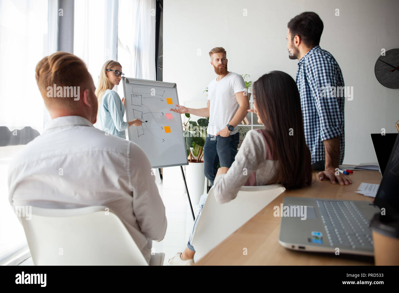 Developing new strategy. Two young colleagues conducting presentation ...