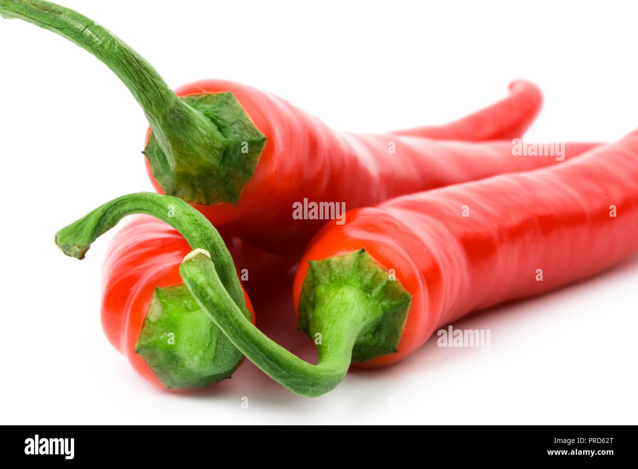 three red chilly peppers closeup on white Stock Photo - Alamy