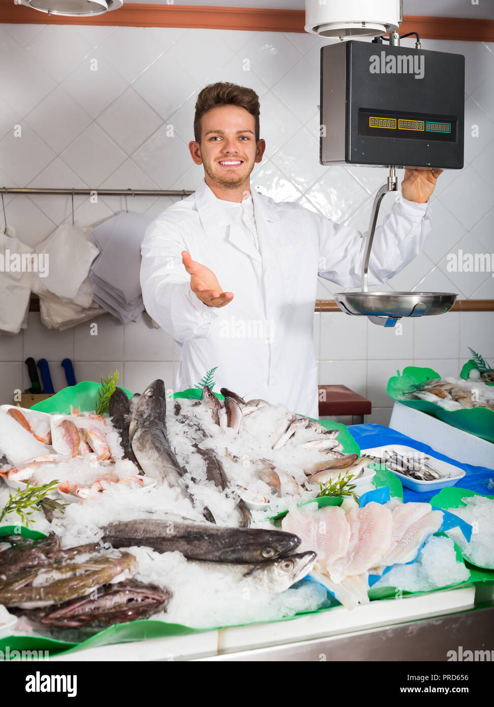 Glad guy selling chilled fish and seafood in store Stock Photo - Alamy
