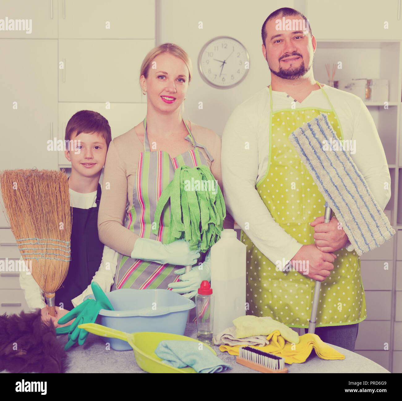Portrait of friendly smiling family standing at room ready to clean ...