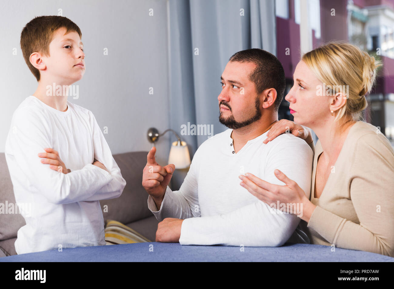 Serious young parents scolding son at home Stock Photo - Alamy