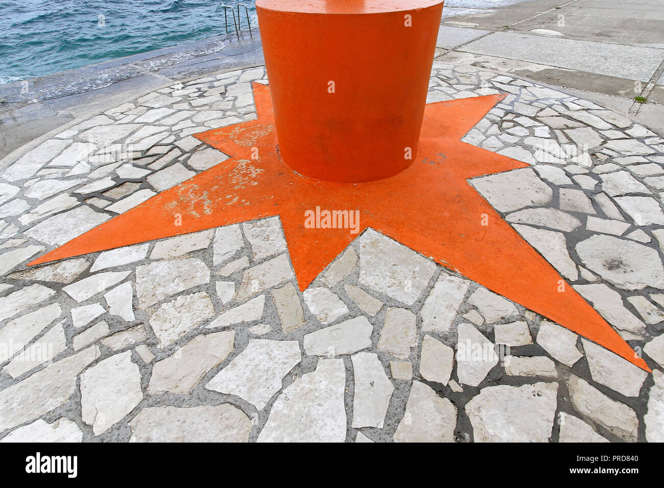 Orange star shape decor at tiles pavement Stock Photo - Alamy