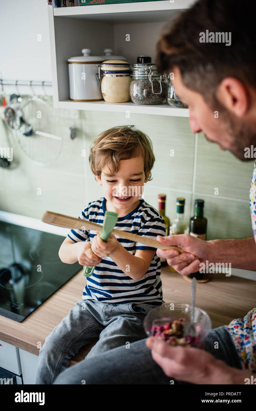 Little boy is having fight with is dad in kitchen Stock Photo - Alamy