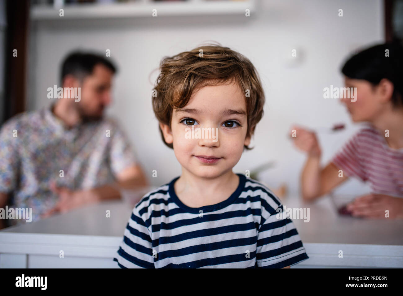 Little boy in his home. His parents are behind him Stock Photo - Alamy