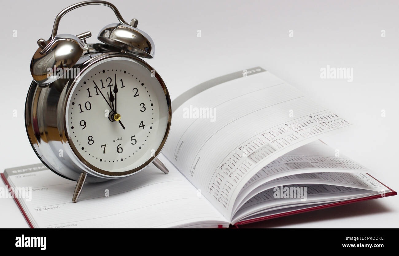 alarm clock and diary on a white background Stock Photo - Alamy