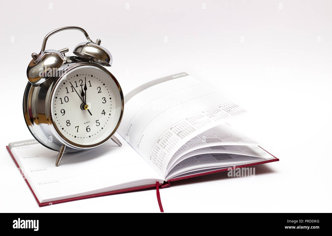 alarm clock and diary on a white background Stock Photo - Alamy