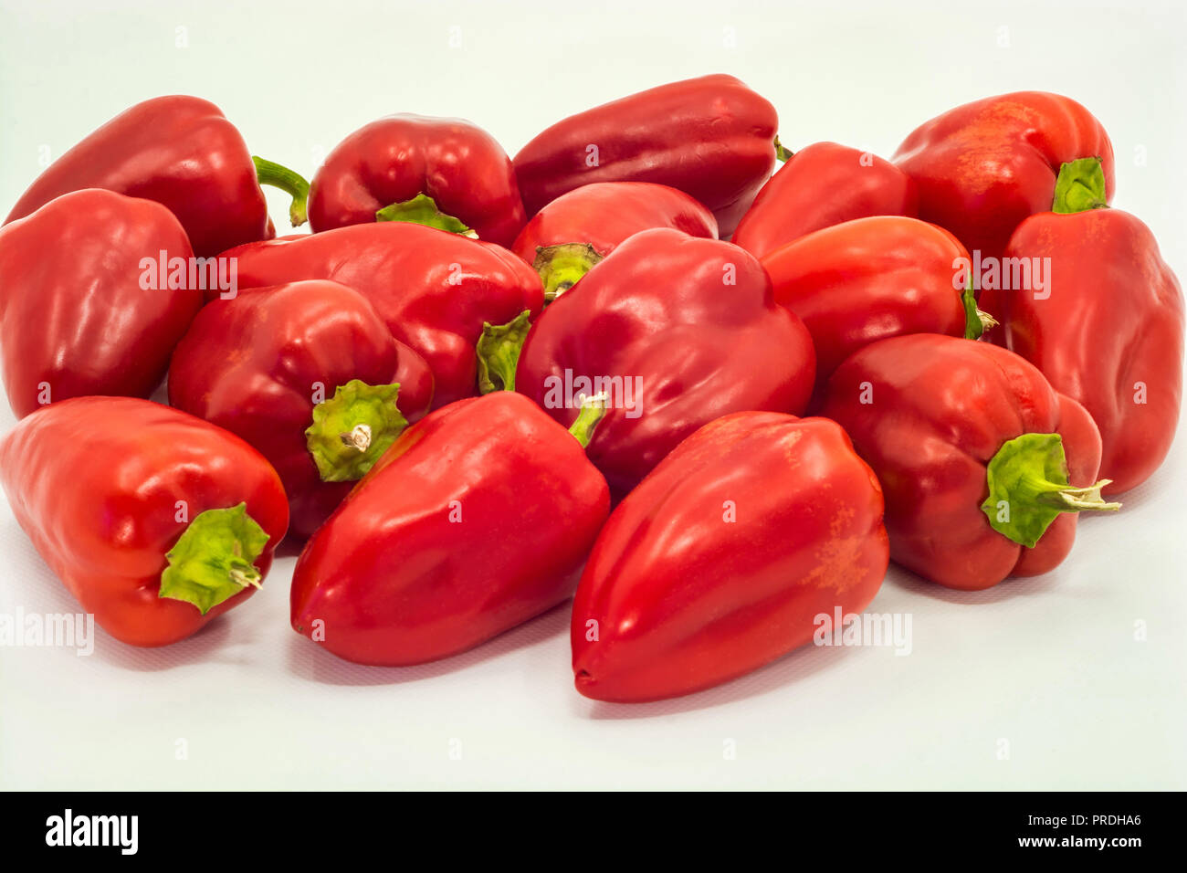 Bright red peppers with green tails on white background Stock Photo - Alamy