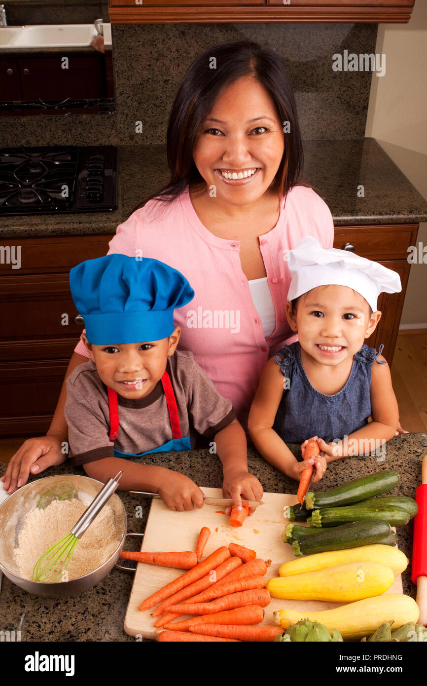 Mother and her children cooking in the kitchen Stock Photo - Alamy
